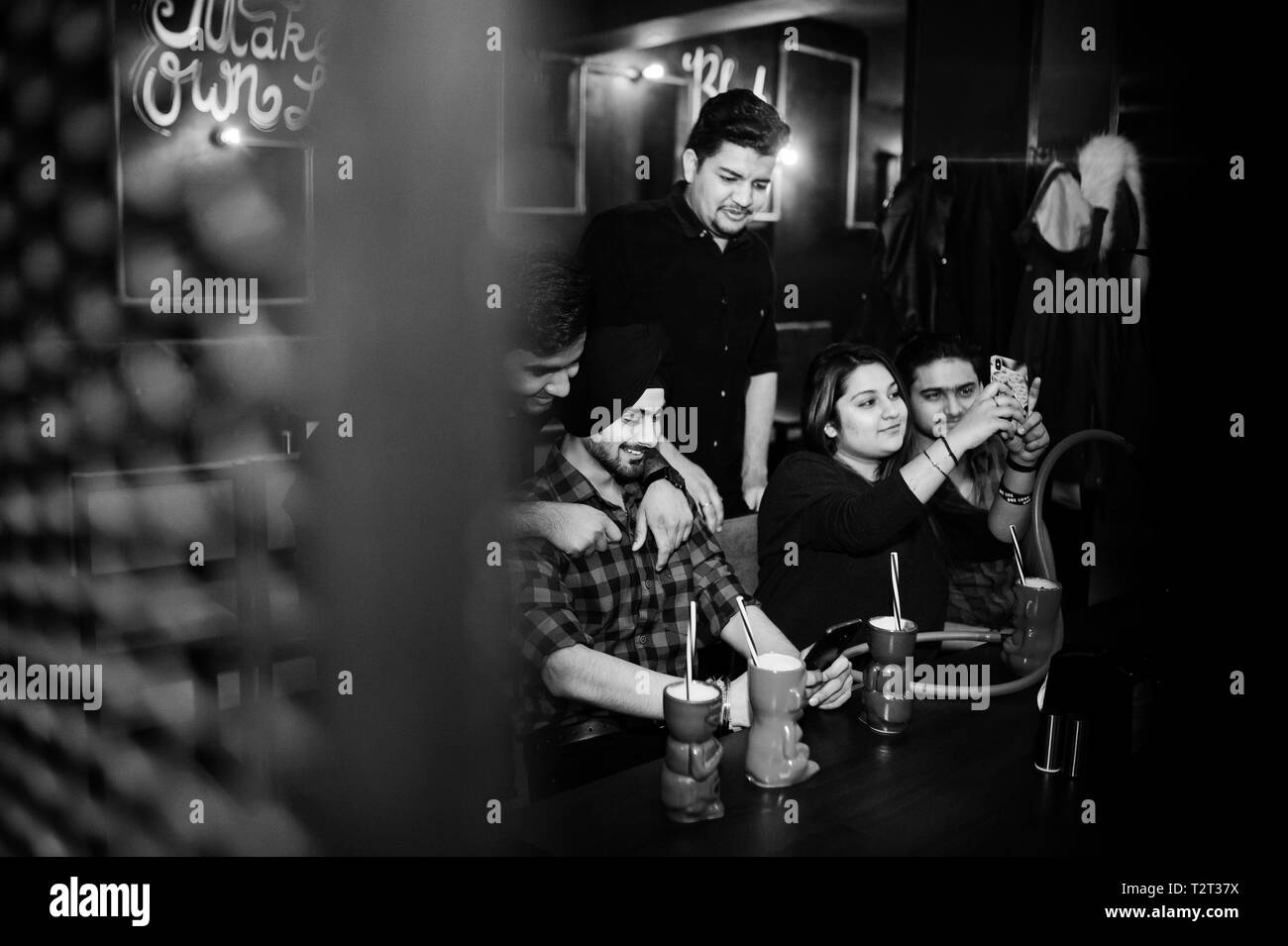 Group of indian friends having fun and rest at night club, drinking ...