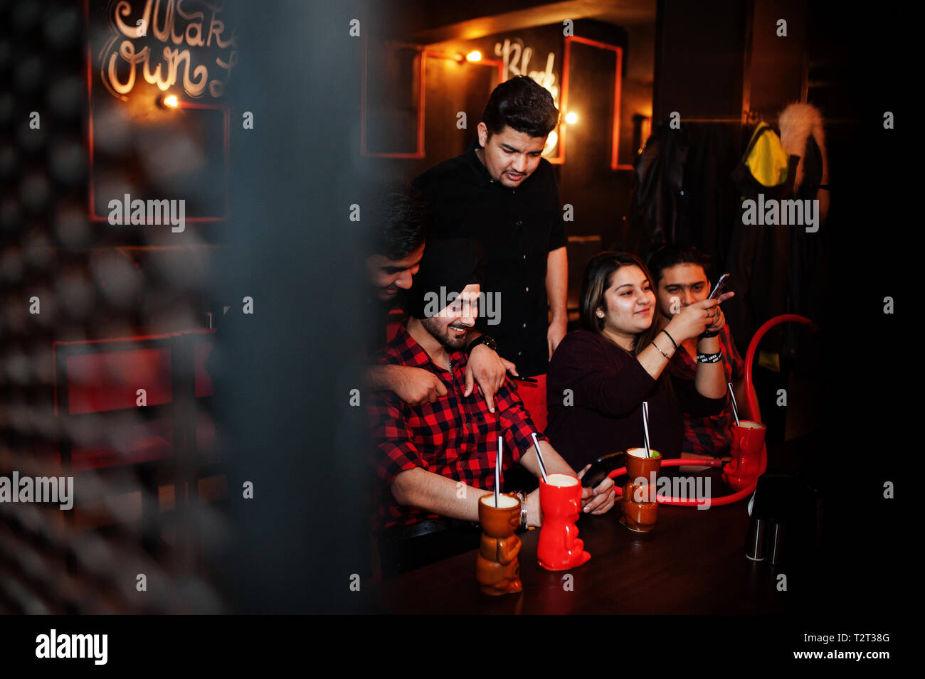 Group of indian friends having fun and rest at night club, drinking ...