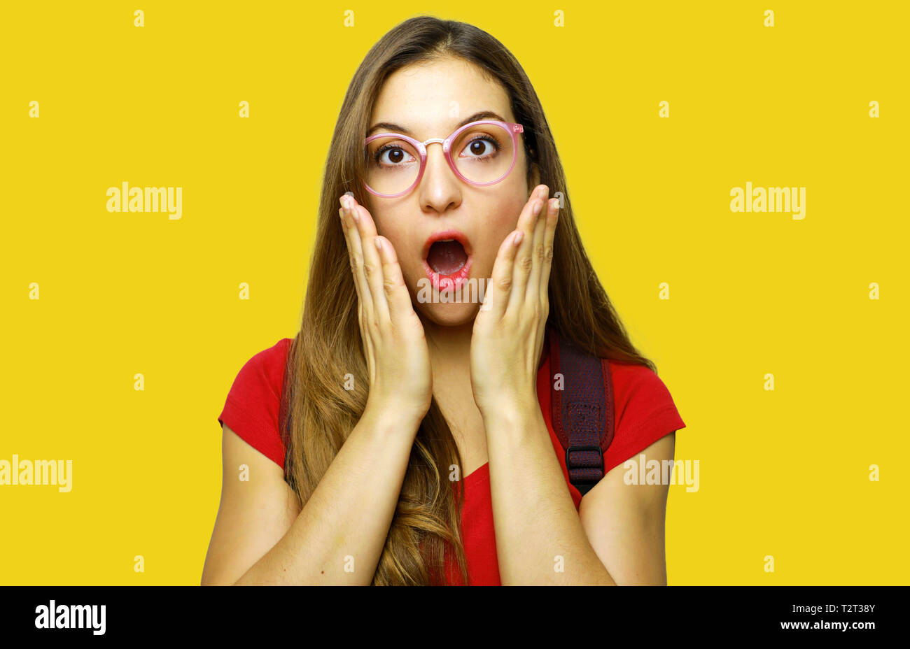 Surprised student with glasses on a yellow background Stock Photo - Alamy