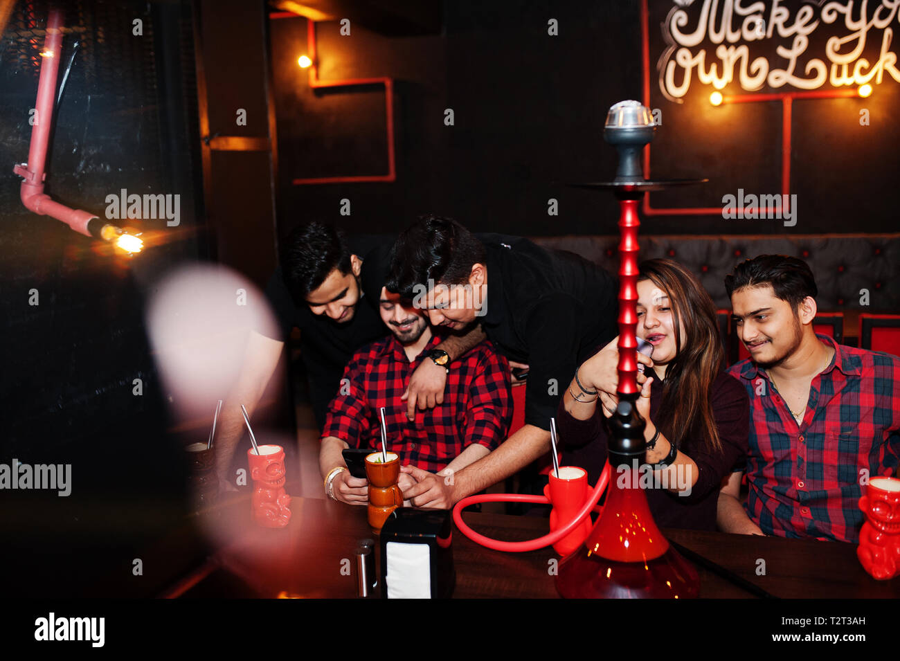 Group of indian friends having fun and rest at night club, drinking ...