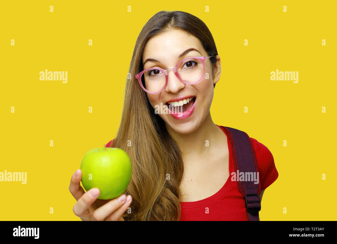 Portrait of a smiling nerd happy girl with glasses and green apple in ...