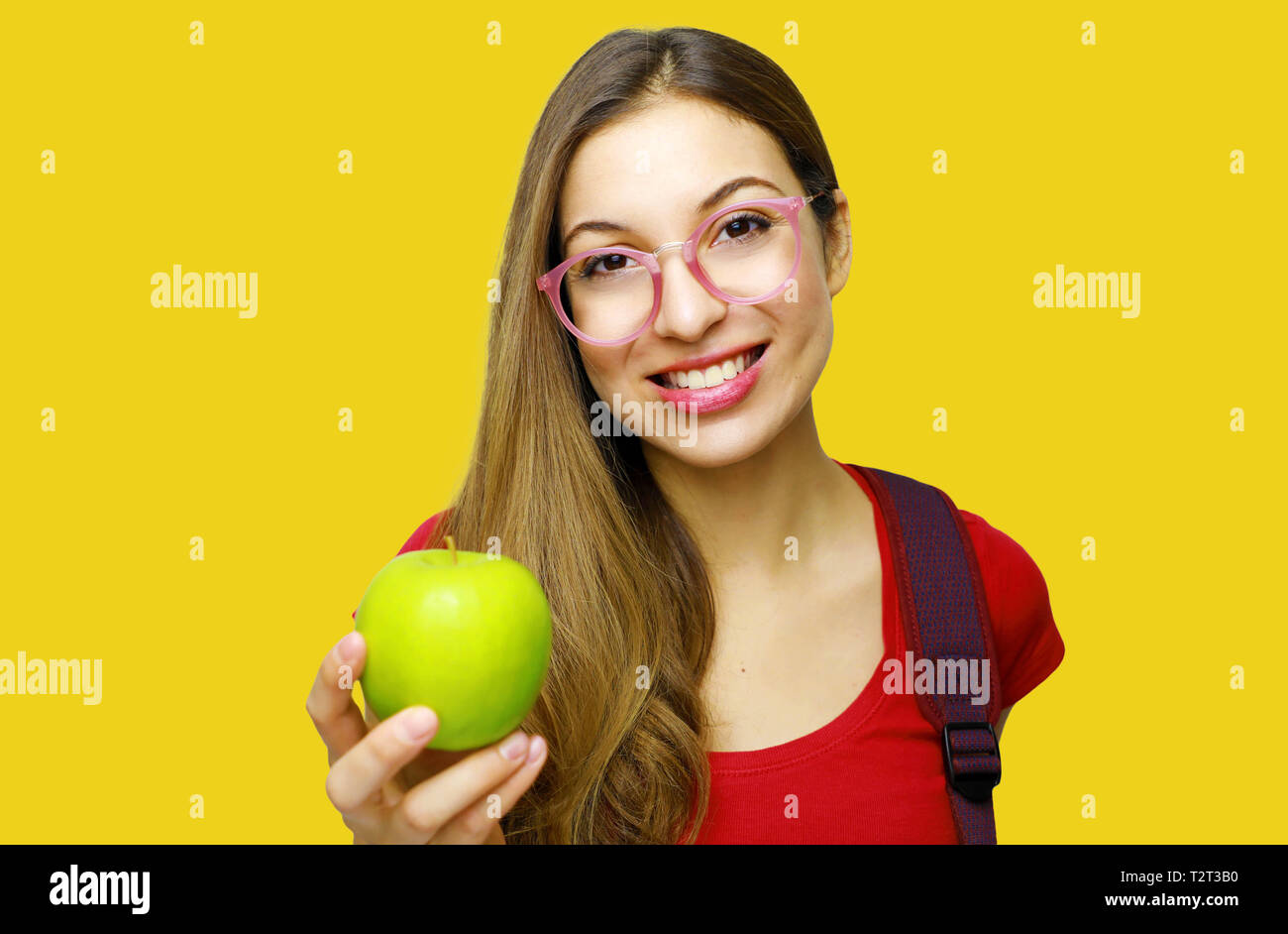 Portrait of a smiling nerd happy girl with glasses and green apple in ...