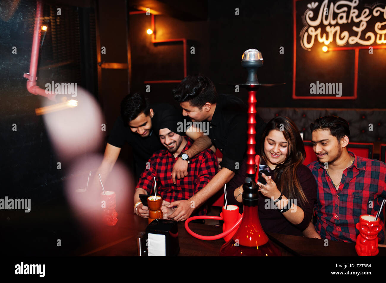 Group of indian friends having fun and rest at night club, drinking ...
