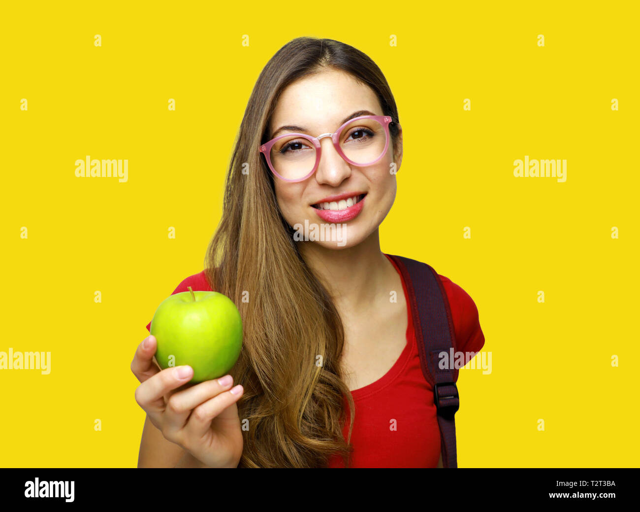 Portrait of a smiling nerd happy girl with glasses and green apple in ...