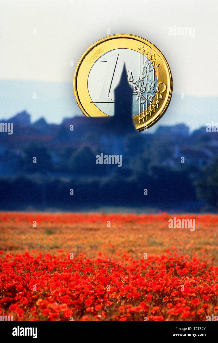 1 euro coin behind a rural landscape with a village (concept Stock ...