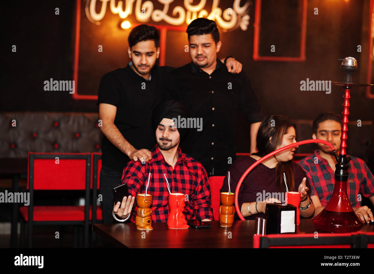 Group of indian friends having fun and rest at night club, drinking ...