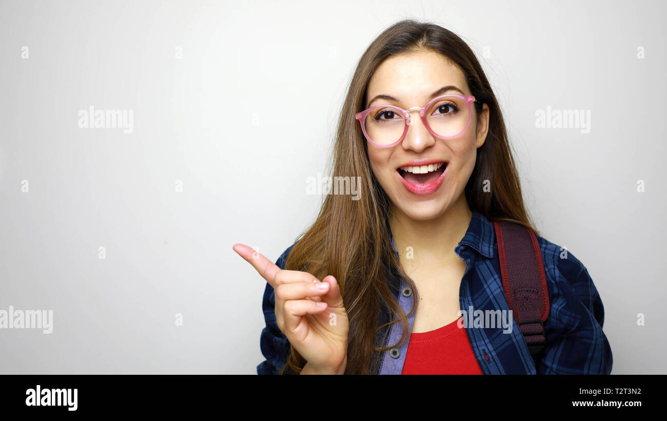 Smiley student girl pointing finger copy space on white background ...
