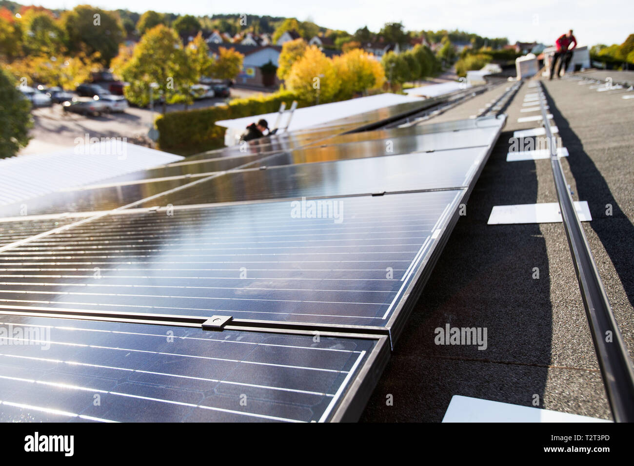 Handyman, with safety harness and safety line, assembles solar cells on ...