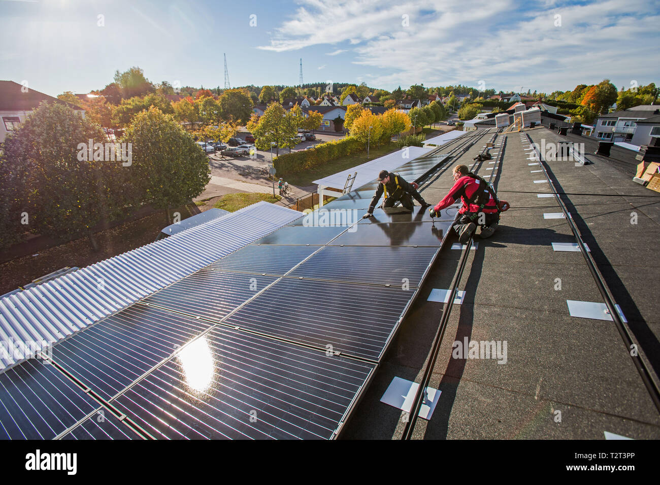 Handyman, with safety harness and safety line, assembles solar cells on ...