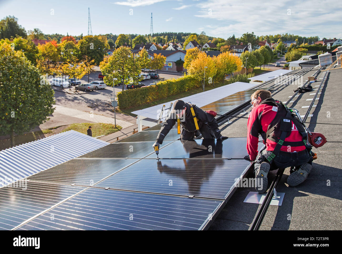 Handyman, with safety harness and safety line, assembles solar cells on ...