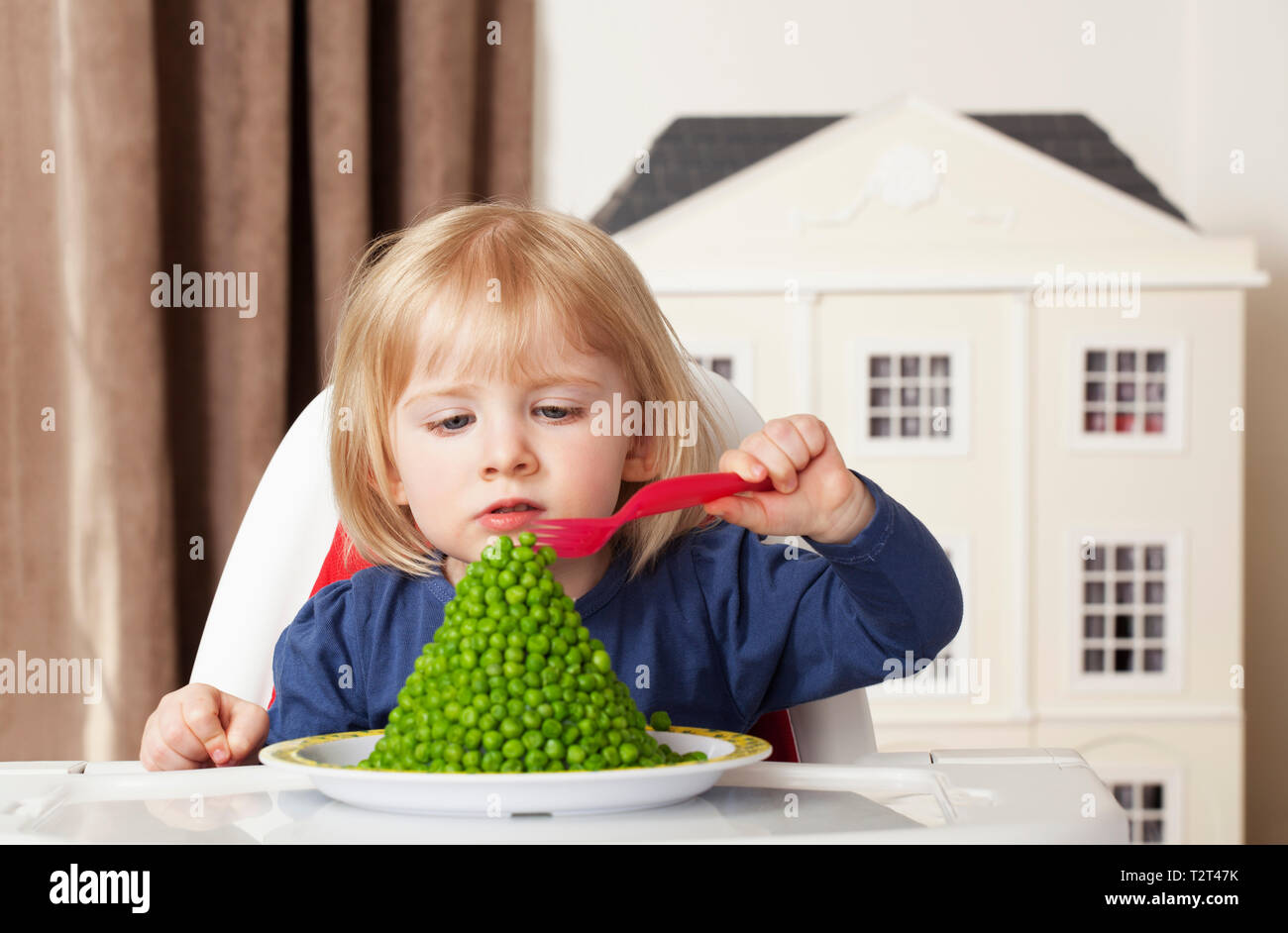 Young caucasian girl eating a plate of peas Stock Photo - Alamy