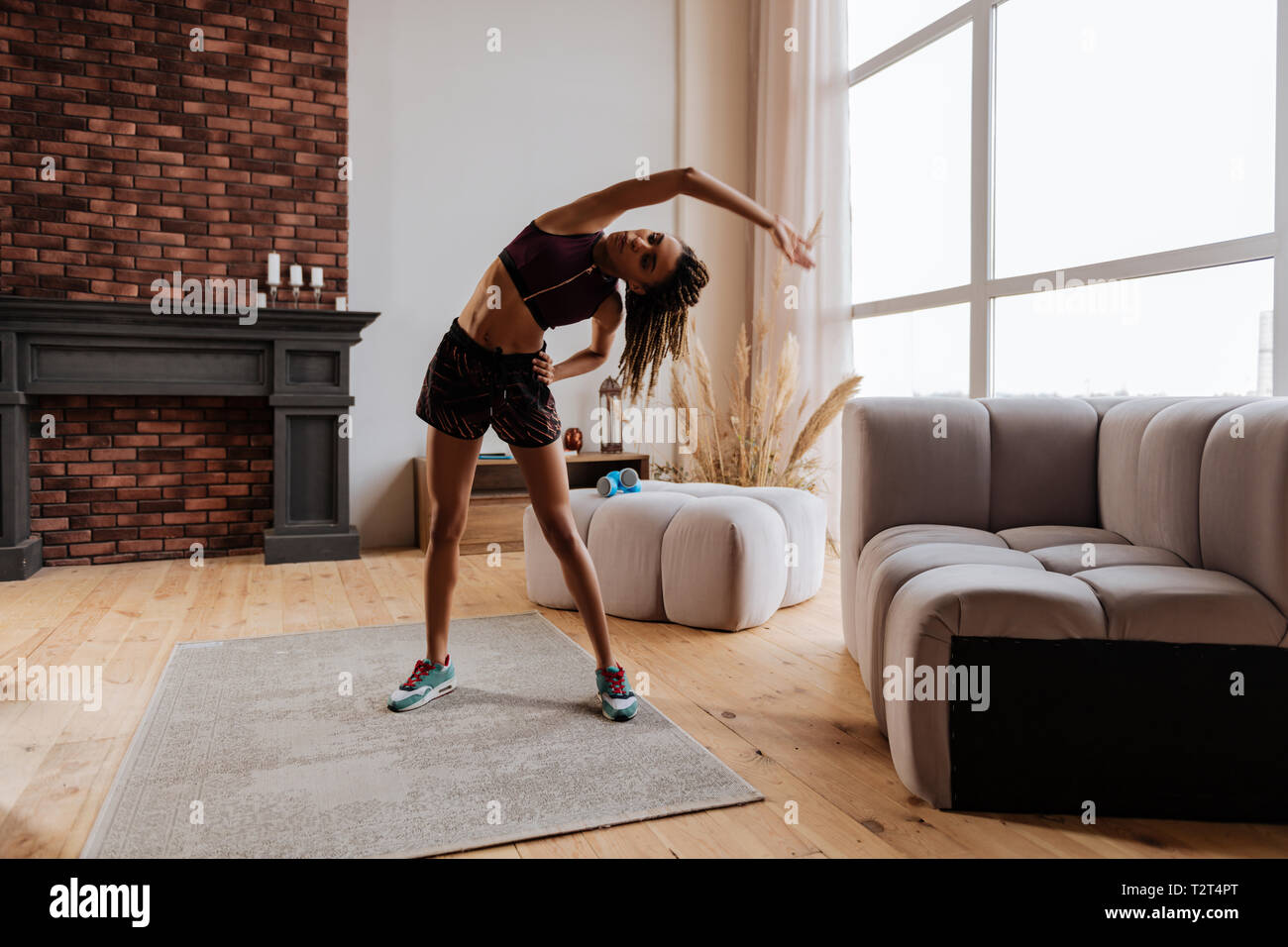 Stretching body. Fit active woman wearing shorts stretching her body ...