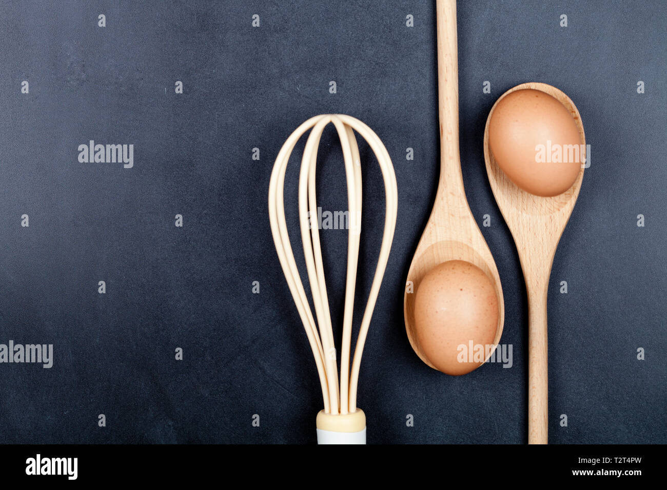Eggs, wooden spoon and whisker. Kitchen utensil for cake, pastry or ...