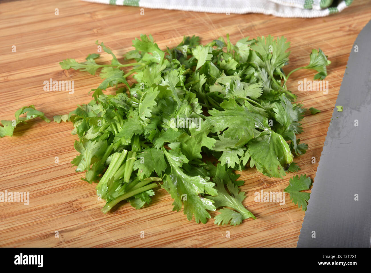 A mound of rough cut cilantro on a cutting board Stock Photo - Alamy