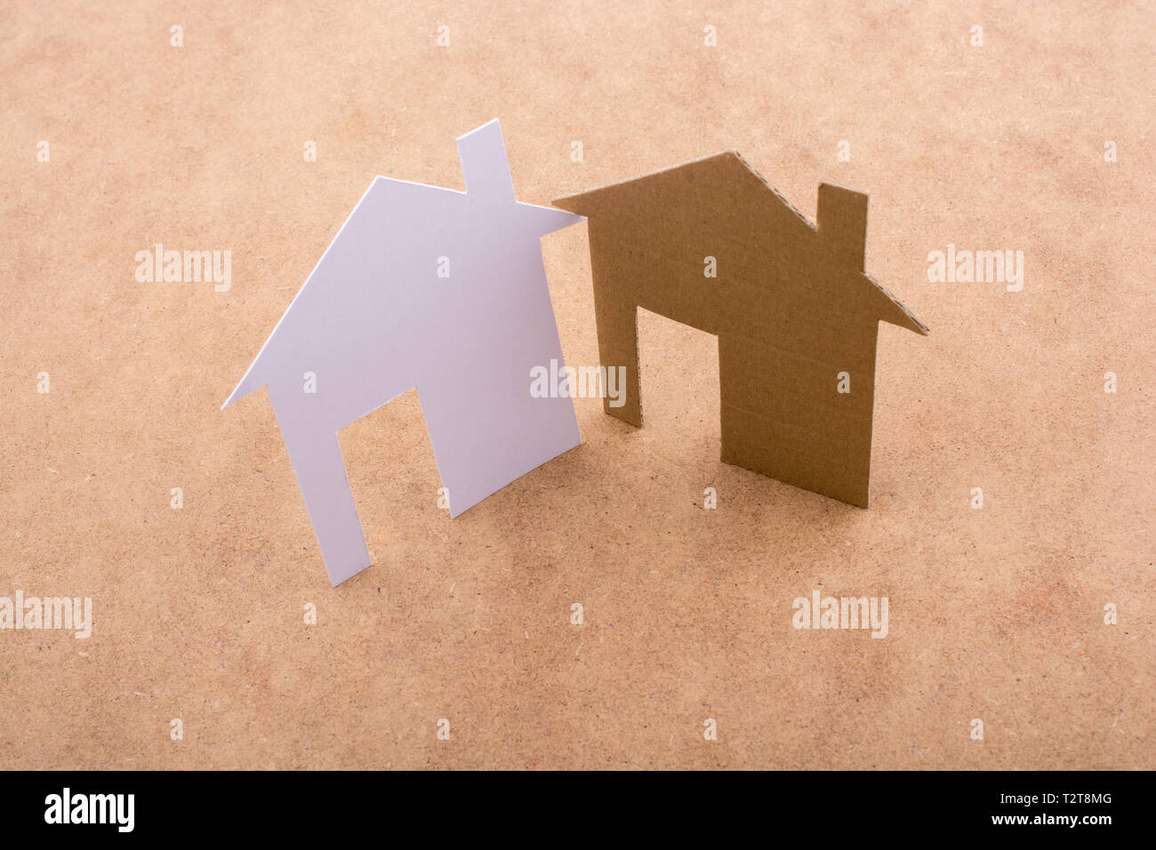 Little paper houses on a brown background Stock Photo - Alamy