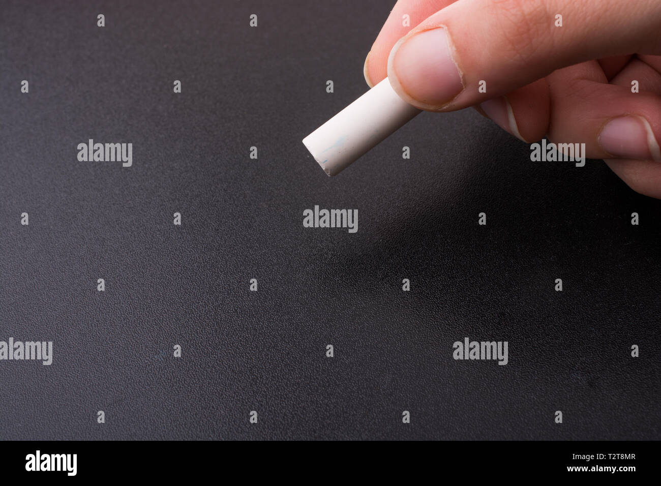 Hand holding white chalk and black board Stock Photo - Alamy