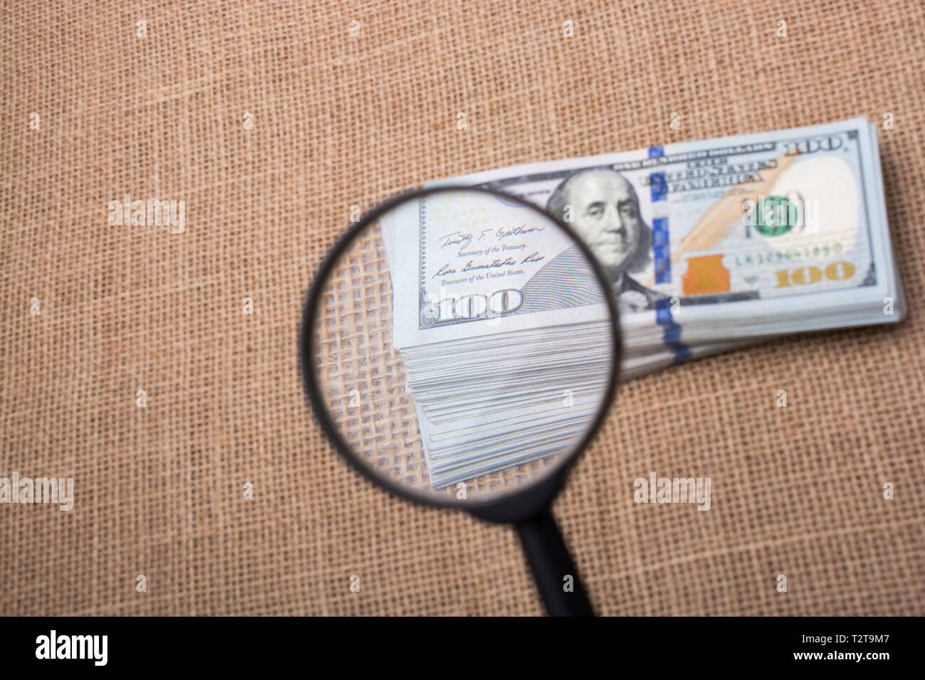 Magnifying glass over the banknote bundle of US dollar Stock Photo - Alamy