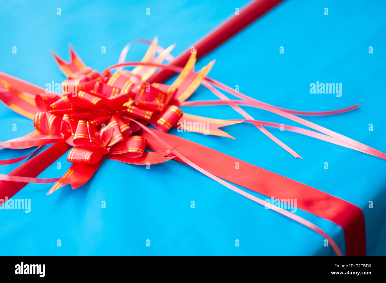 red ribbon on blue box present Stock Photo - Alamy