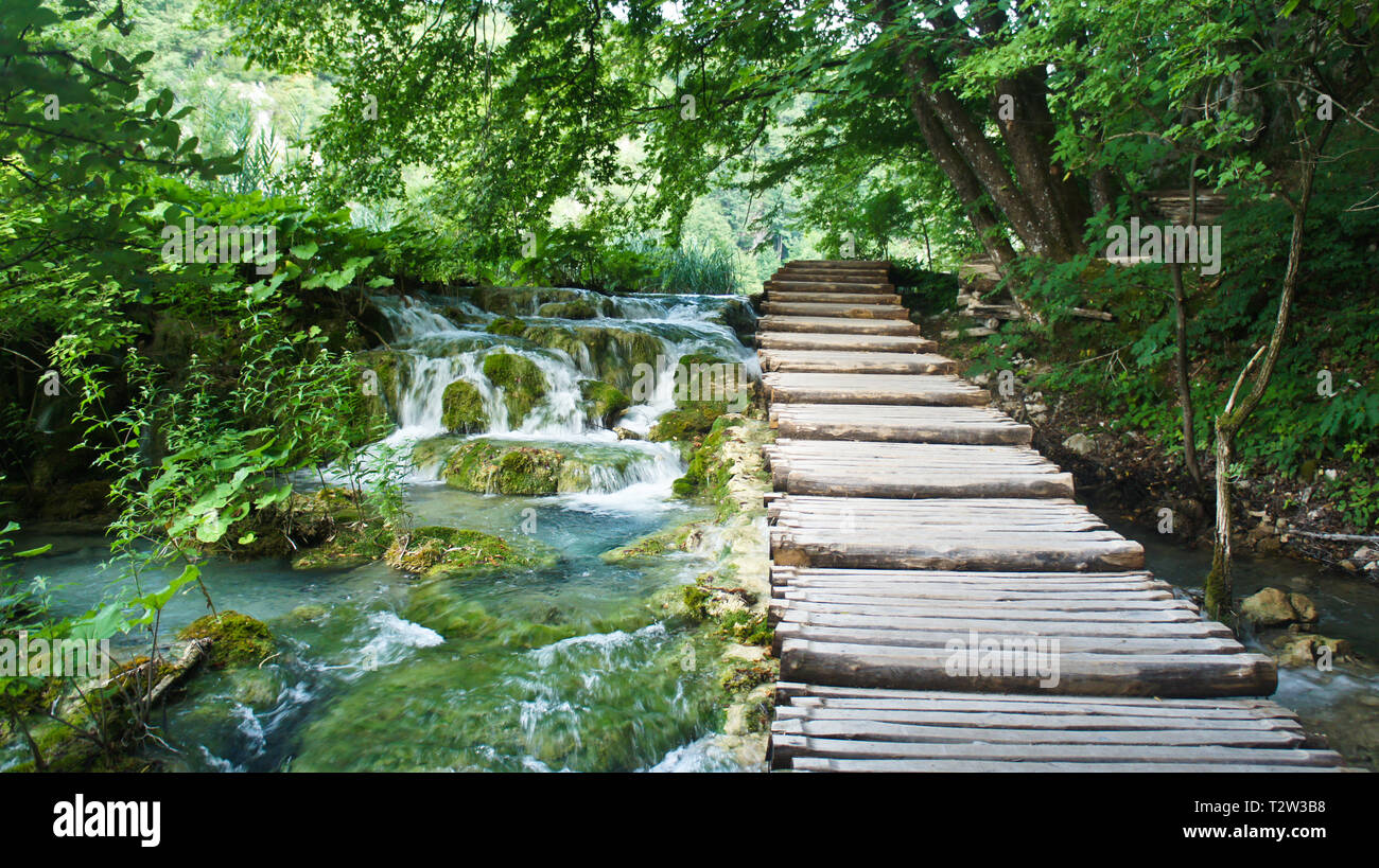 Cascade waterfalls and wooden pathway over the water, Plitvice Lakes in ...