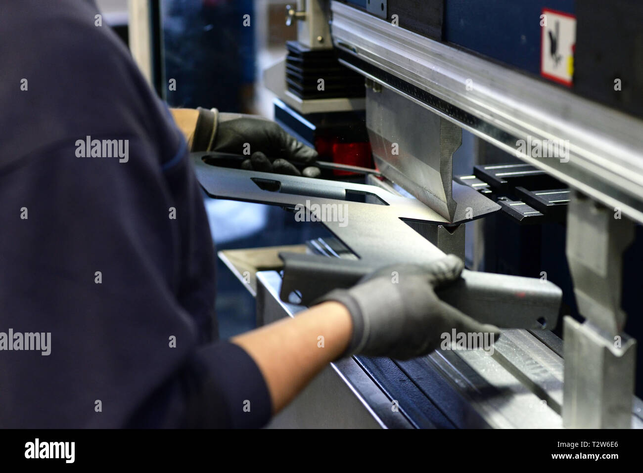 employee operates bending machine in a metalworking company - bending ...