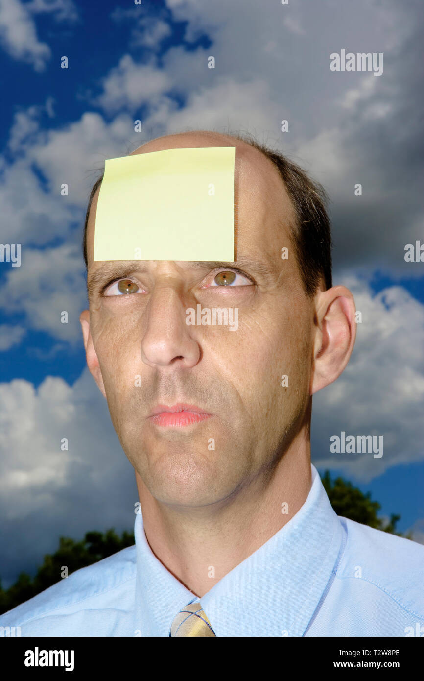 Caucasian middle aged businessman with a sticky note stuck to his ...