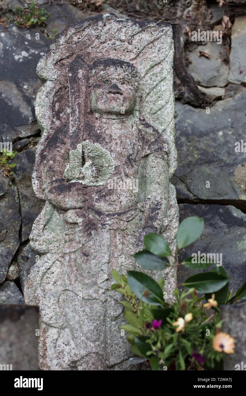 A carved figure in stone at a small shrine in Nara, Japan Stock Photo ...