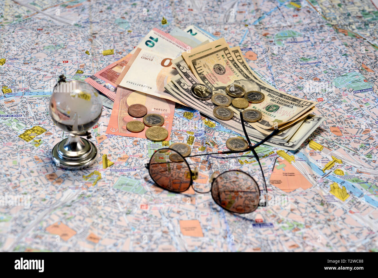 Sunglasses, a glass globe and money on a tourist map background ...