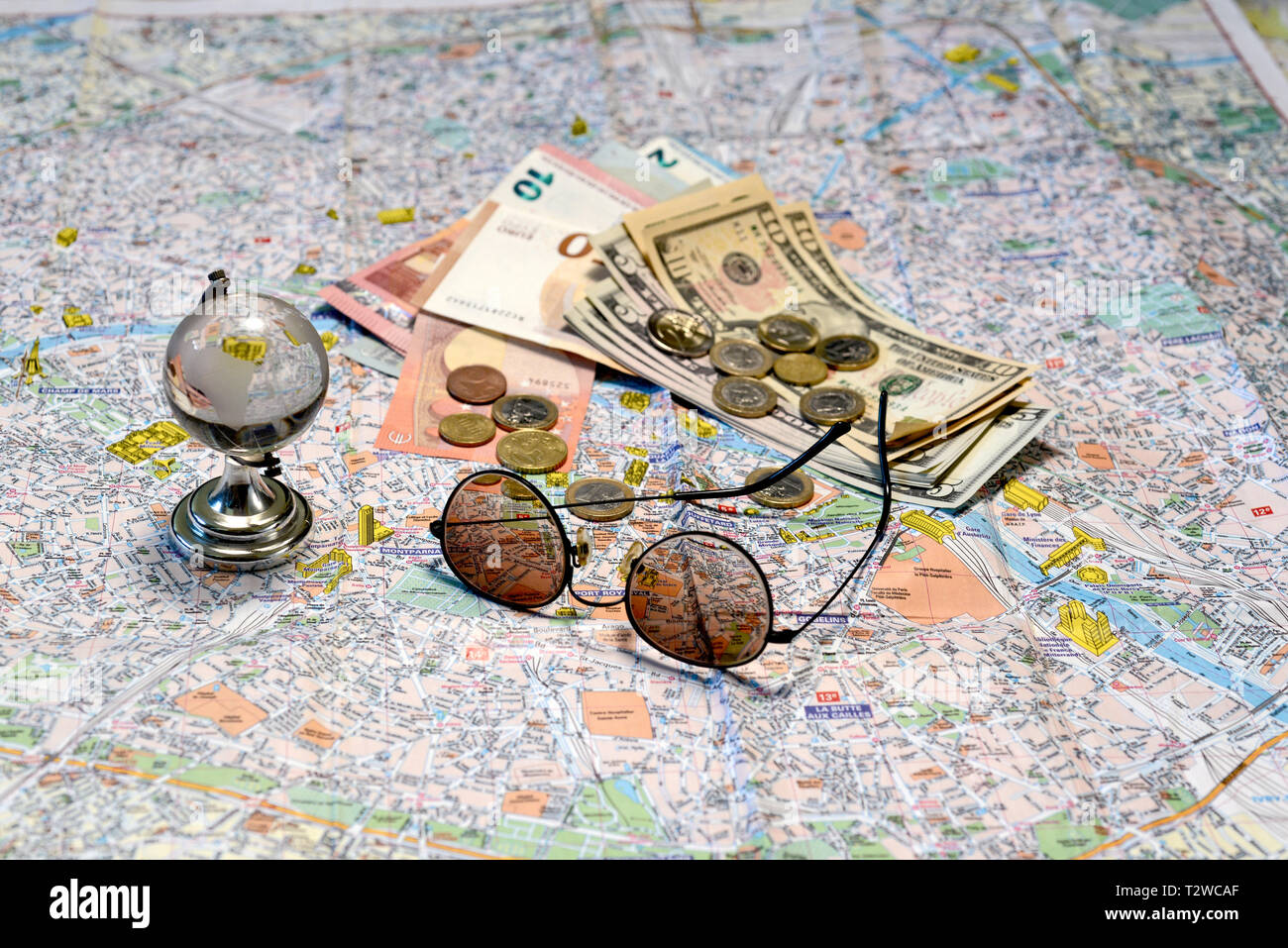 Sunglasses, a glass globe and money on a tourist map background ...