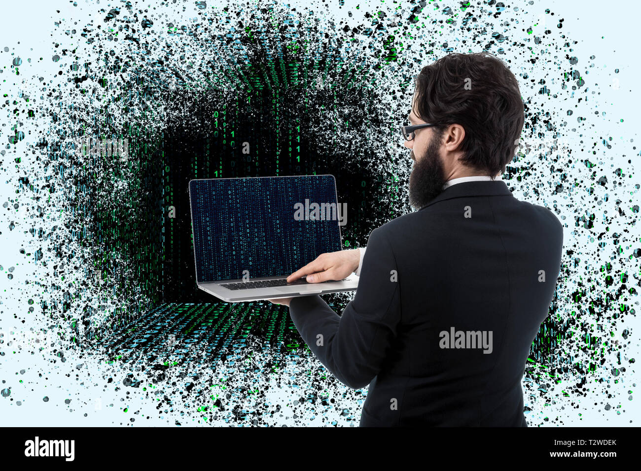 Back view of a standing programmer holding and using laptop with binary ...