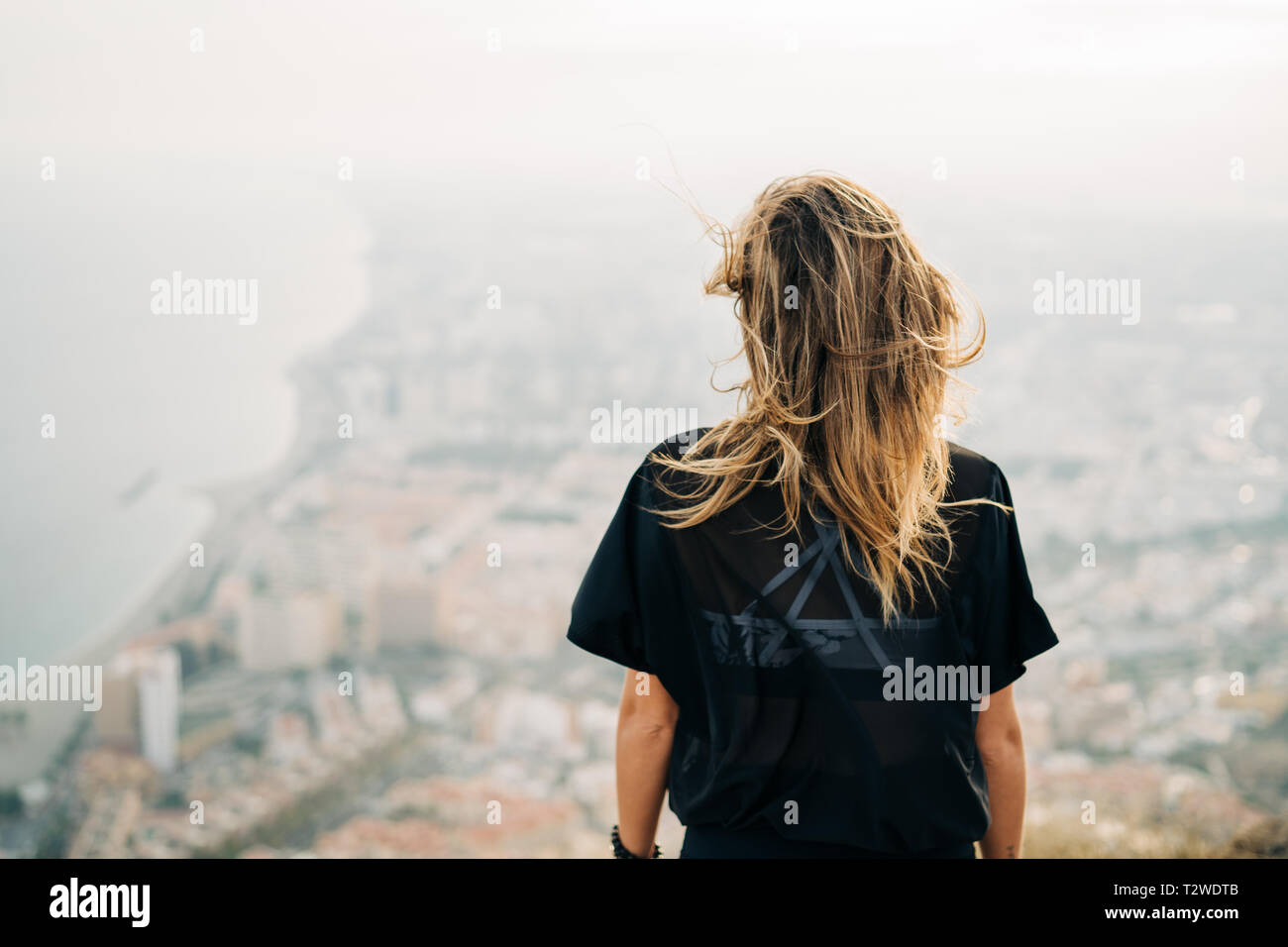 Young woman on top of the mountain looking at the city from above Stock ...