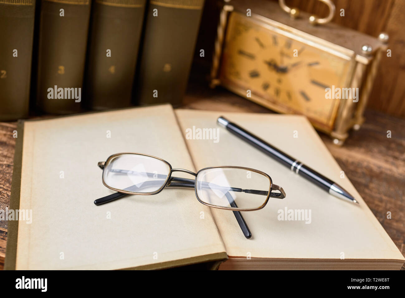 Open book with eyeglasses and a pen for notes. Open books ready for ...