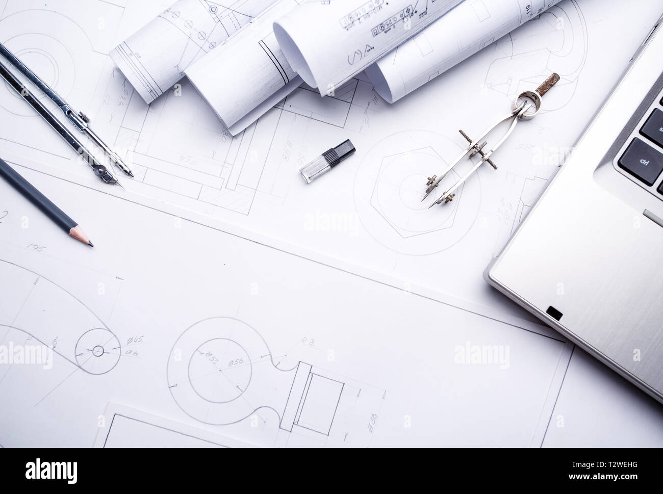 Laptop with several drawing tools on drawings. Engineering and ...