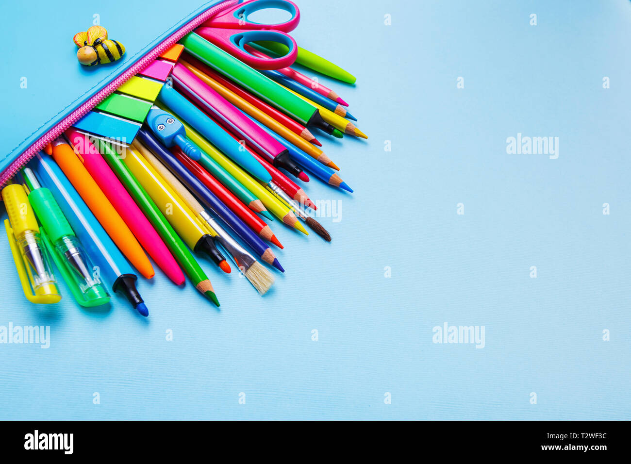 Light blue pencil case with a red star and colored stationery on a blue ...