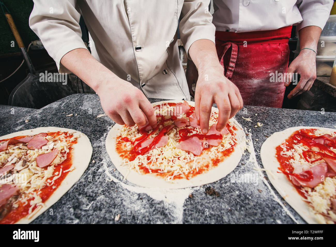 Cooking pizza in the pizzeria. Stages of cooking pizza Stock Photo - Alamy
