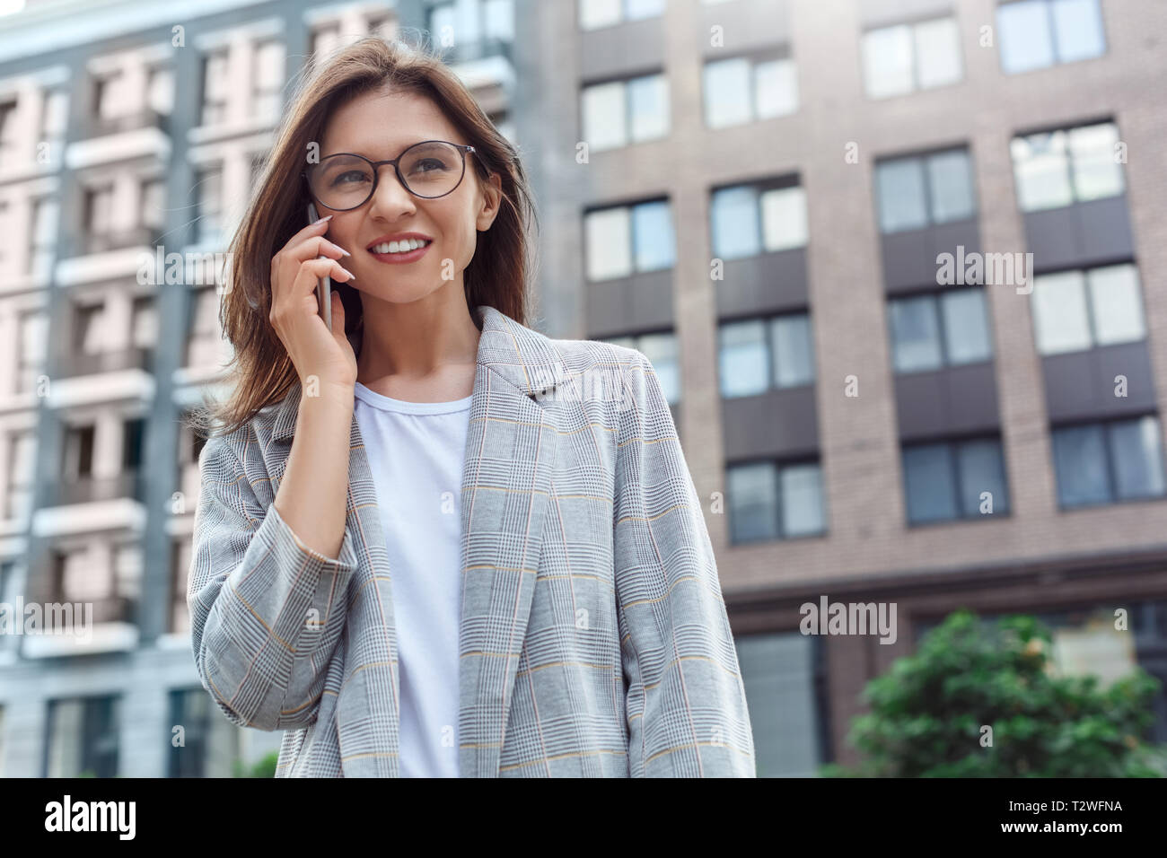 Young businesswoman wearing eyeglasses standing on the city street ...