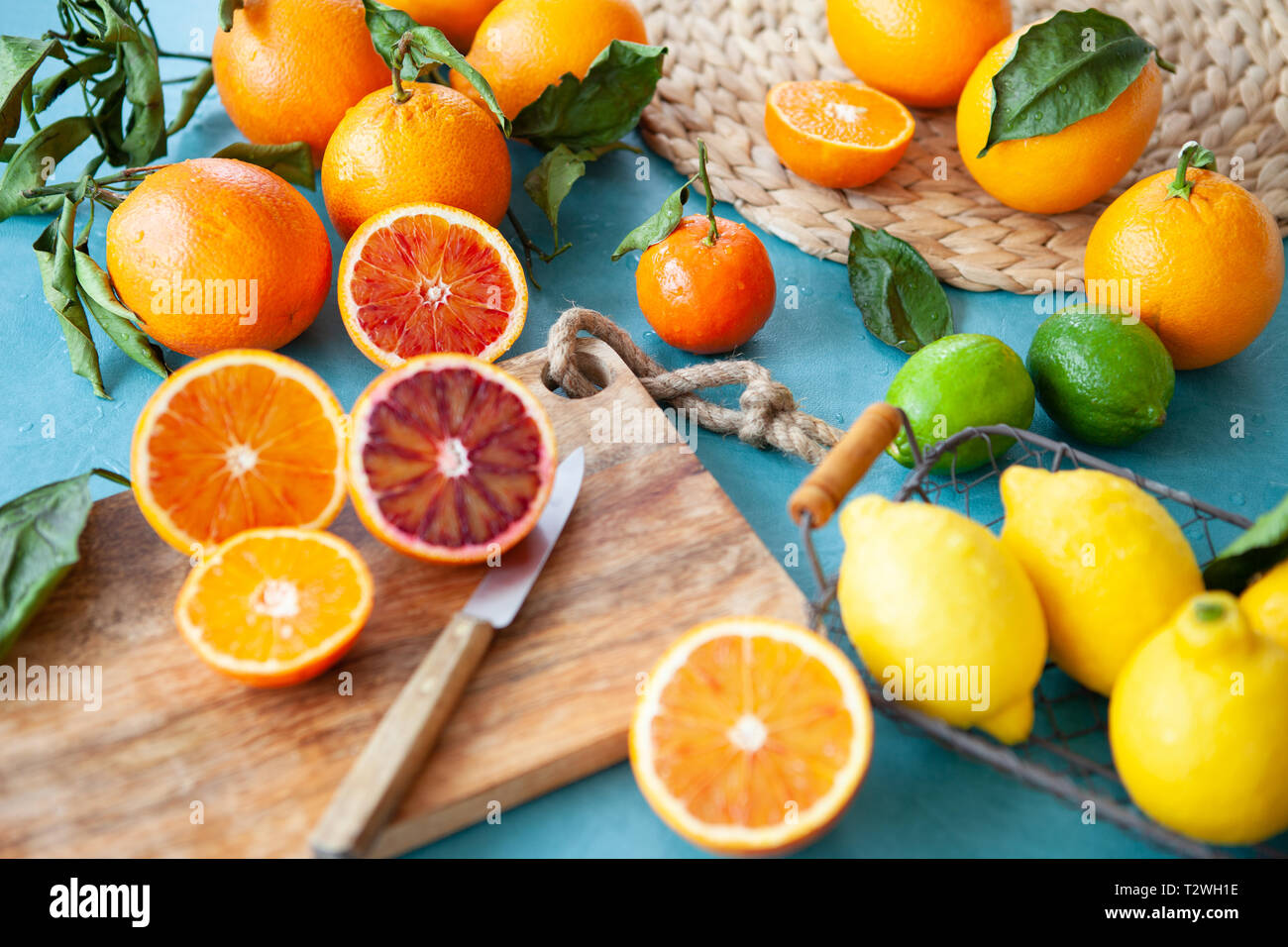 Variety of fresh citrus fruits on a blue background Stock Photo - Alamy