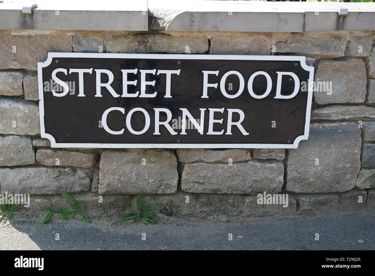 Street Food Corner sign on stonewall Stock Photo - Alamy