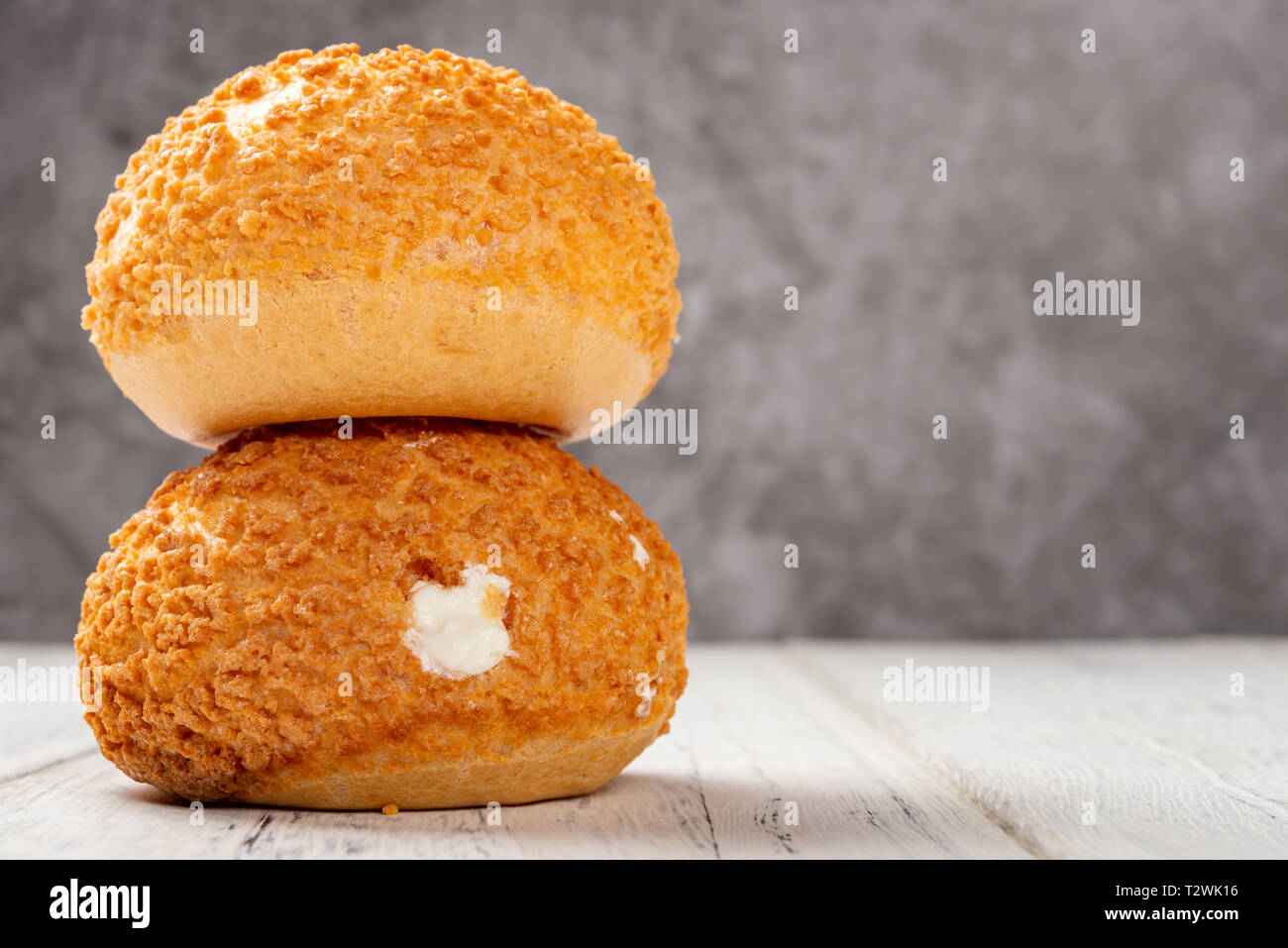 two pieces sweet puffs on a white wood table Stock Photo - Alamy