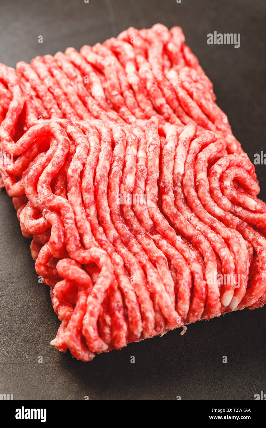 Fresh raw minced beef in frying pan and ingredients over dark ...