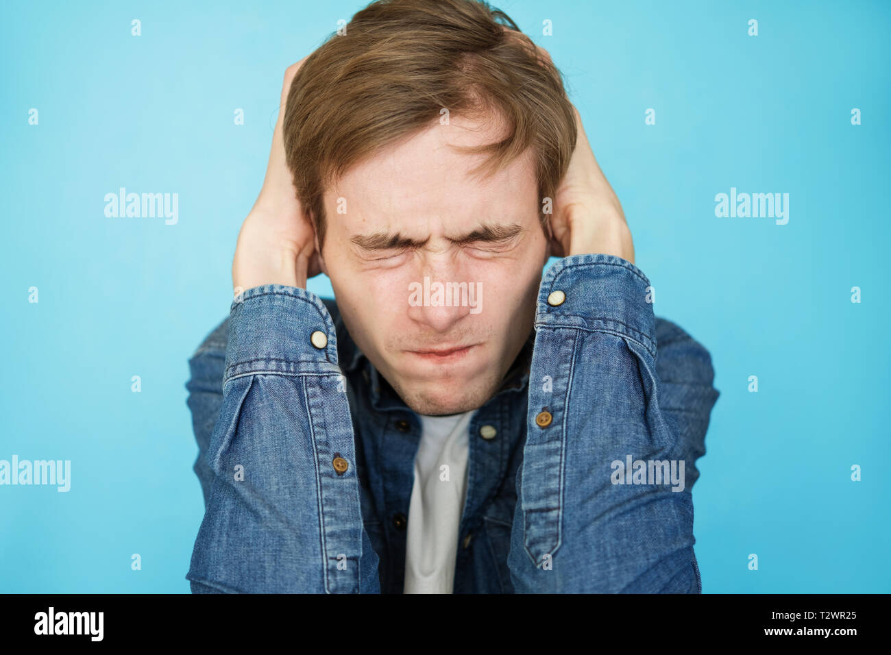 young aggressive male teenager in denim shirt on blue background Stock ...