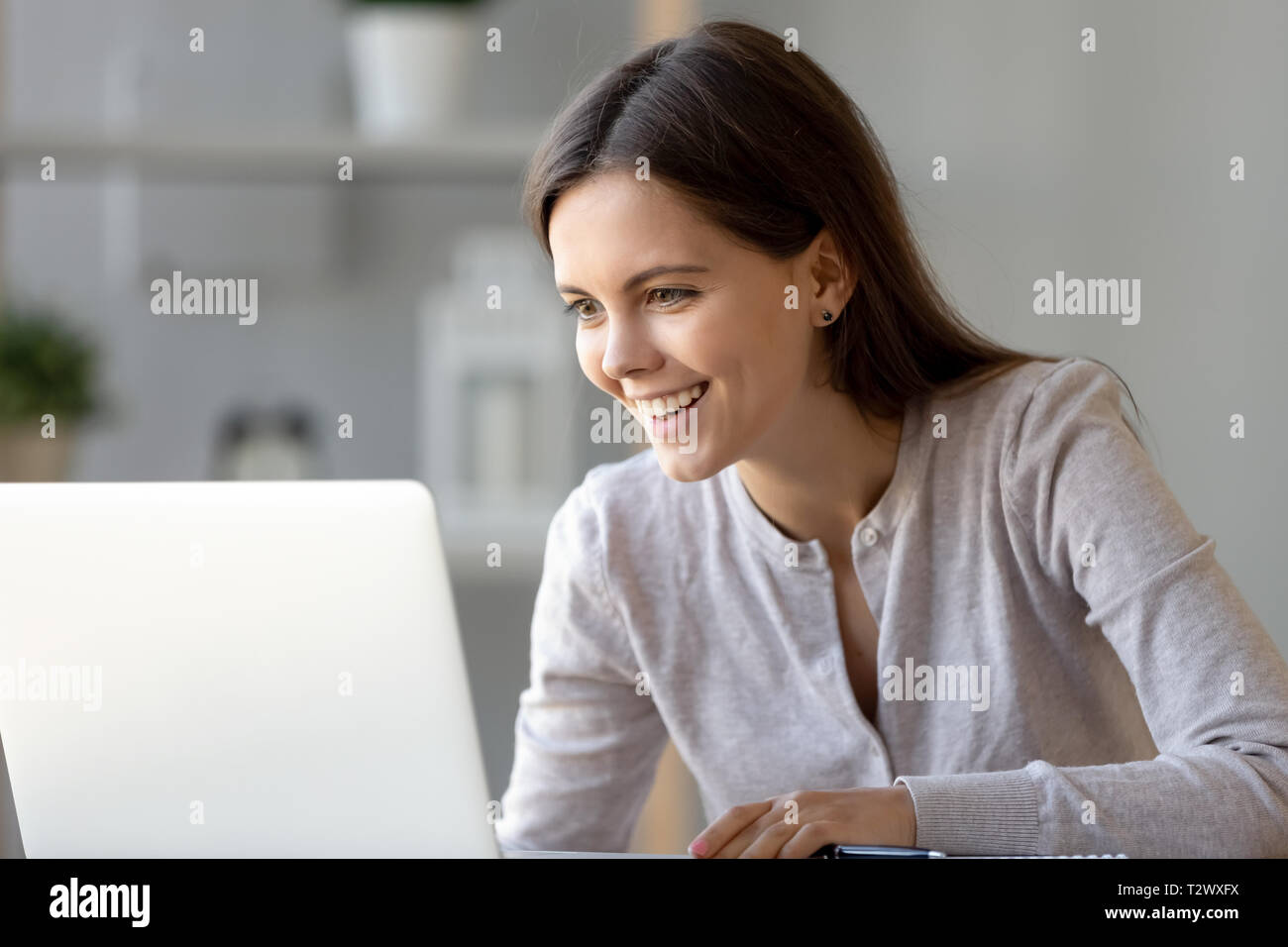 Happy woman reading pleasant e-mail looking on computer screen Stock ...
