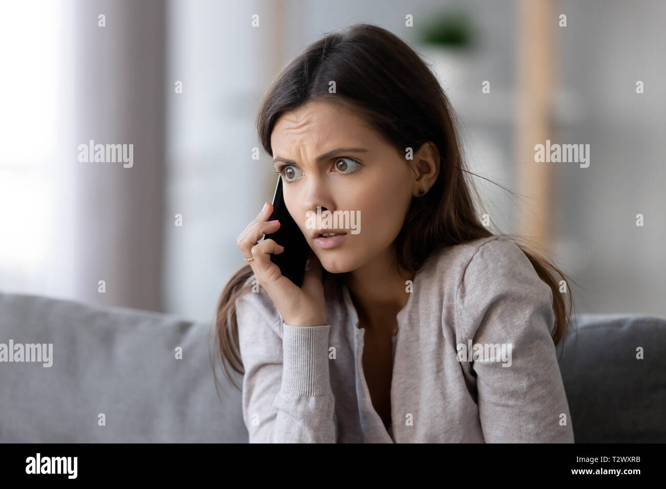 Shocked or scared young woman talking on mobile phone Stock Photo - Alamy