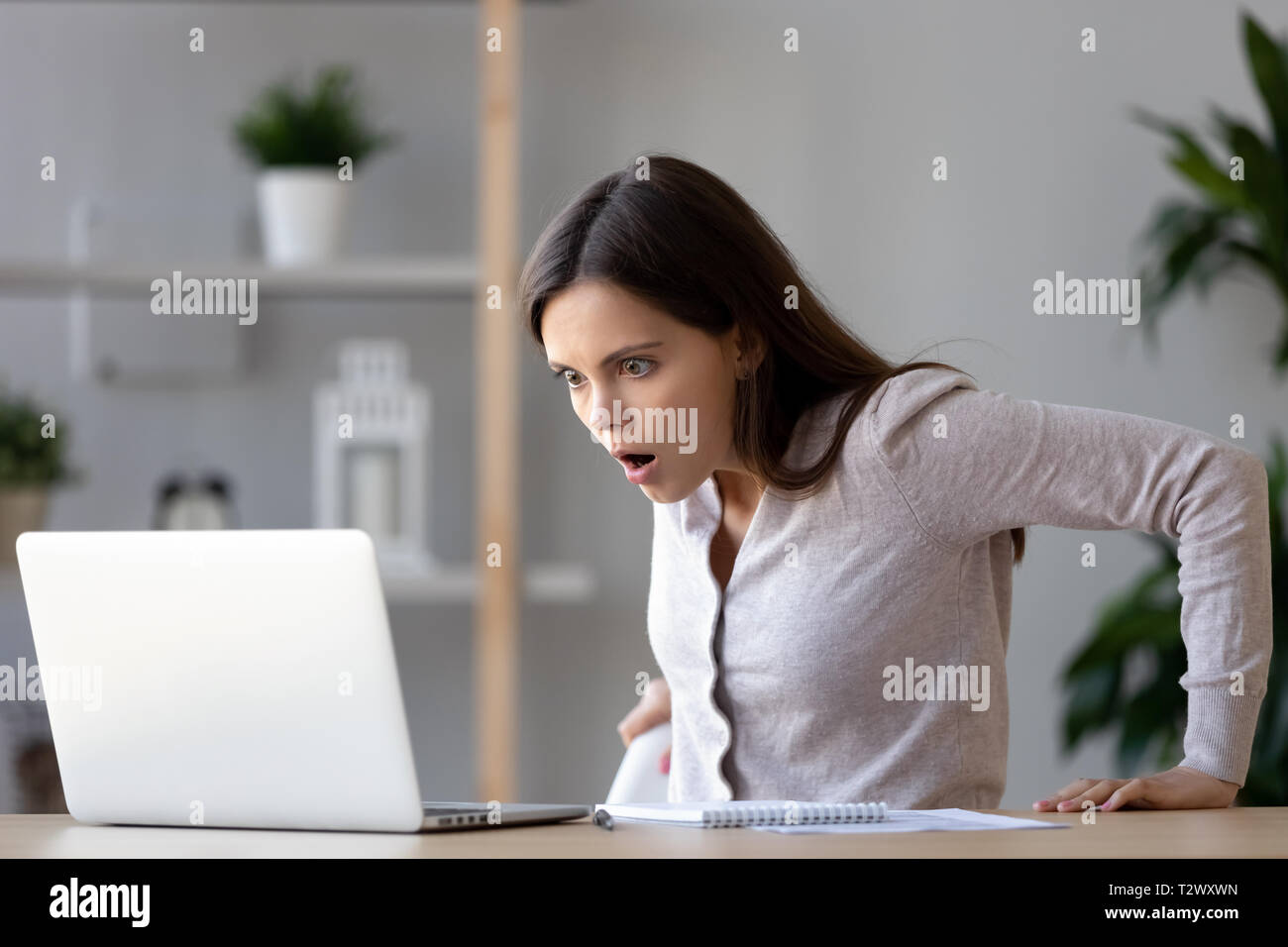 Shocked woman looking at laptop screen surprised with bad news Stock ...