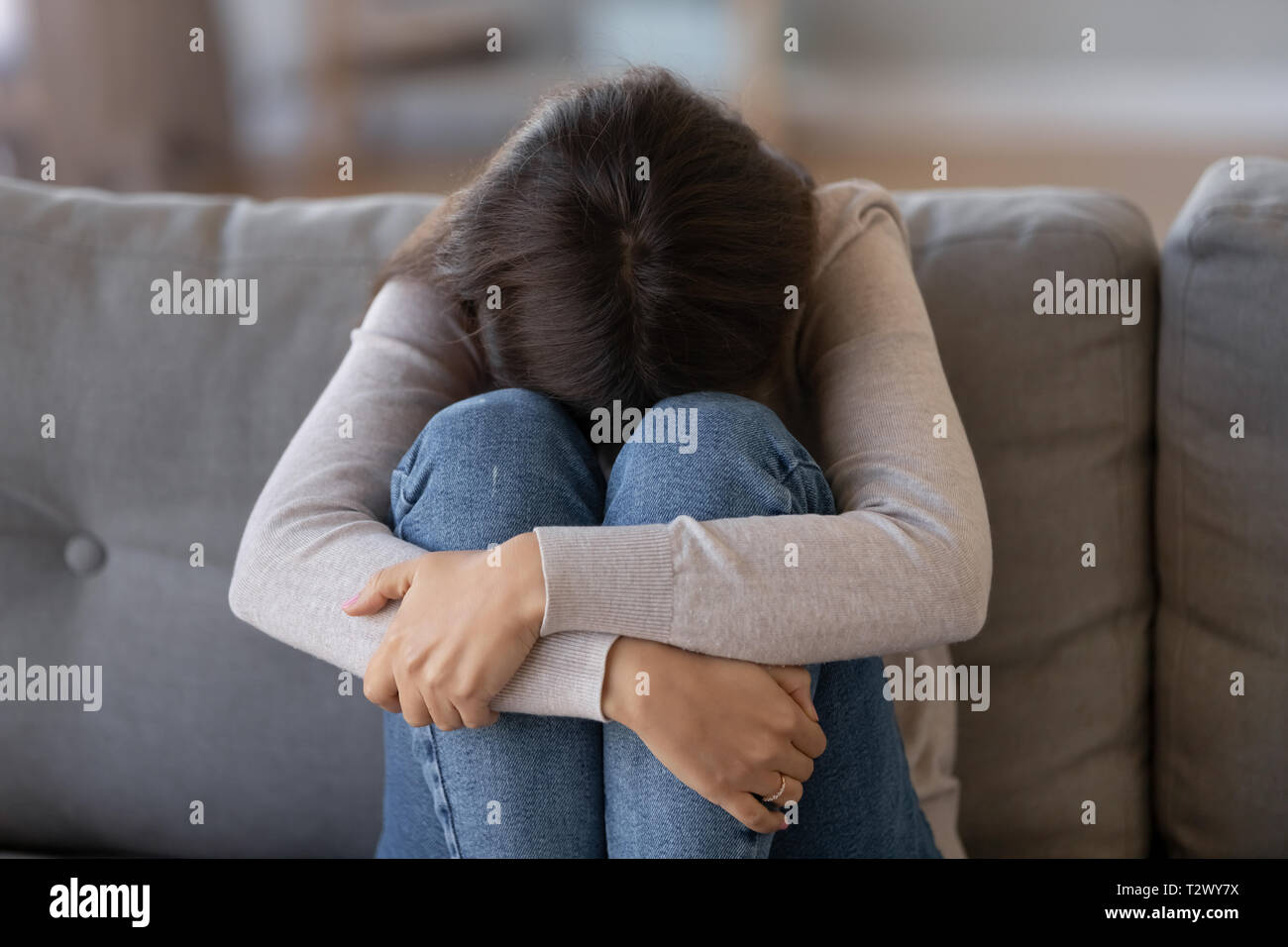 Depressed woman sitting on couch feeling unhappy crying alone Stock ...