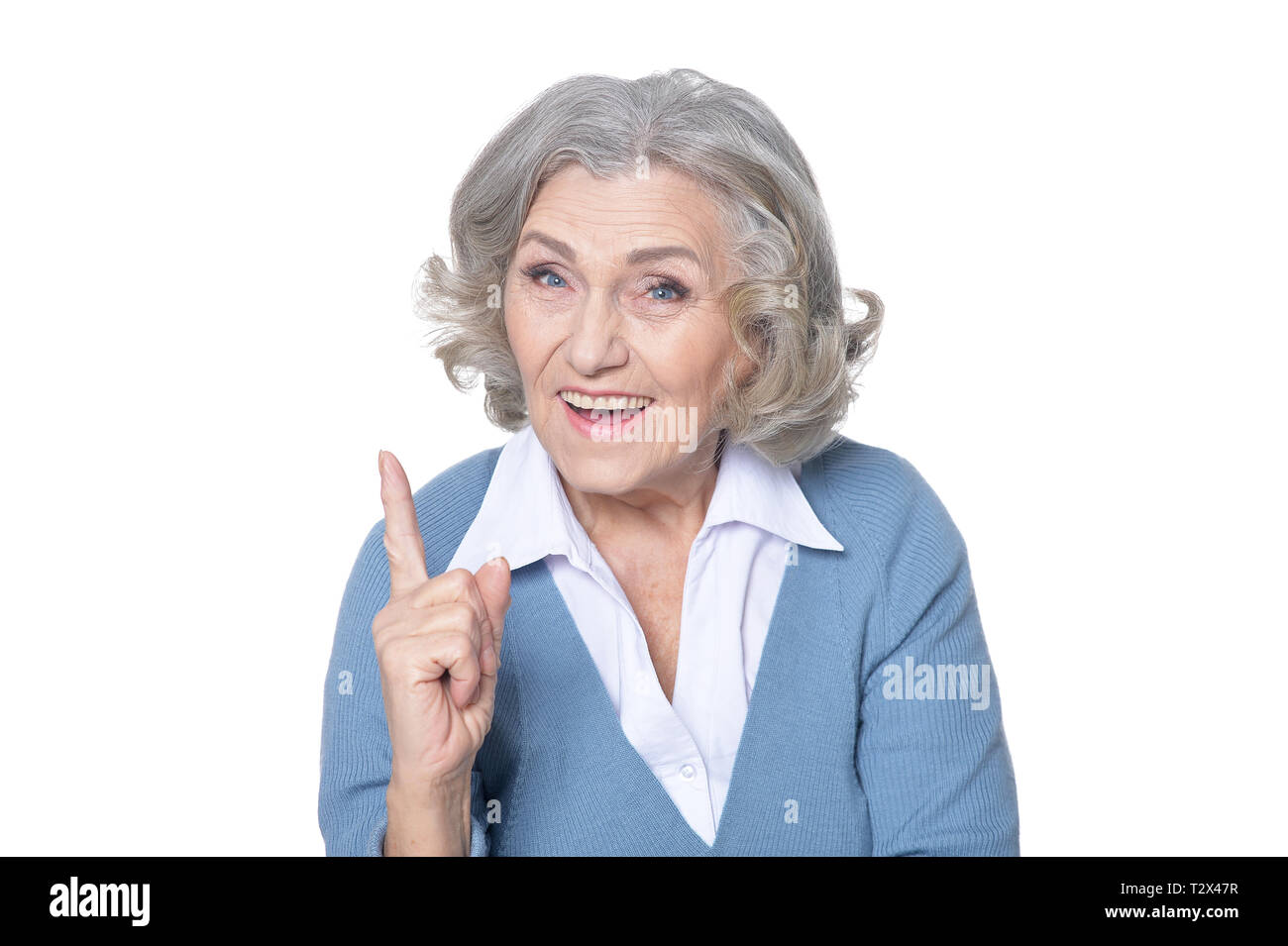 Portrait of beautiful senior woman pointing upwards with finger against ...