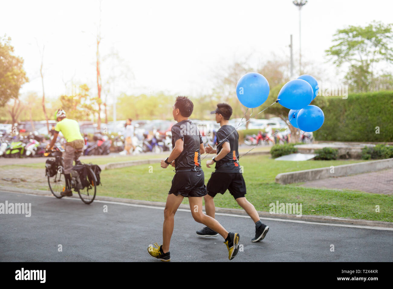 Selected focus two marathon running in the park with blue balloon in ...