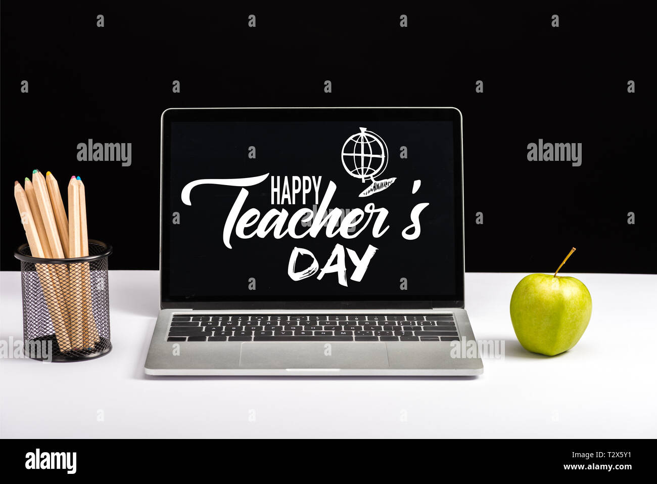 fresh green apple, color pencils and laptop on table with happy ...