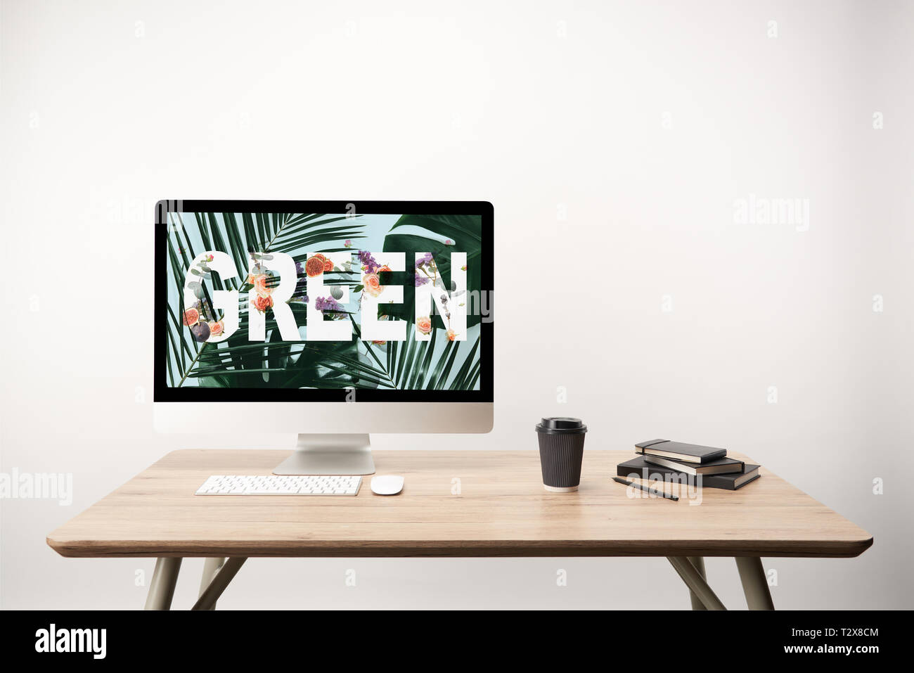 computer with green leaves and green lettering on monitor on wooden ...