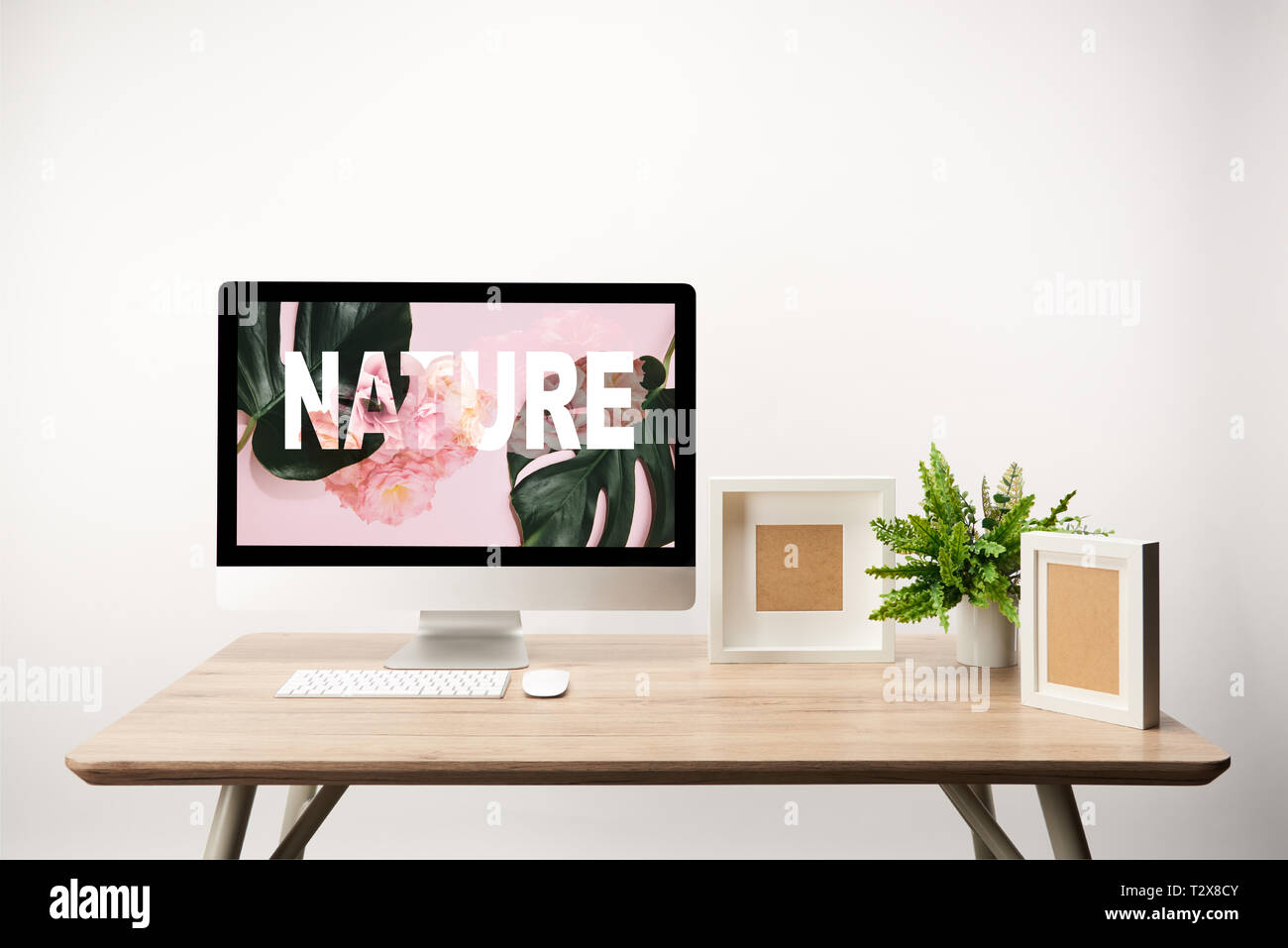 computer with green leaves and nature illustration on monitor on wooden ...