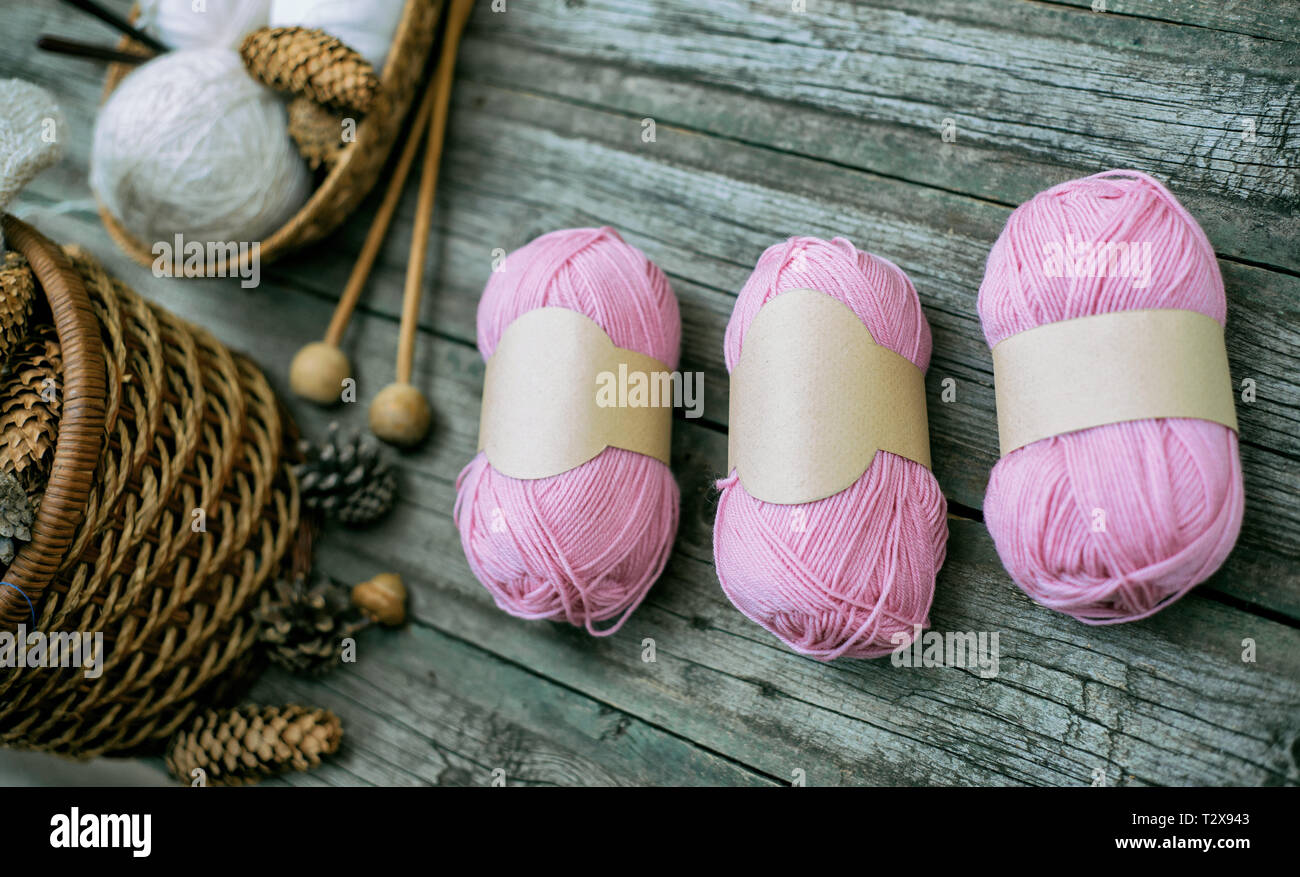 Three pink balls of wool threads with empty labels lying on vintage ...